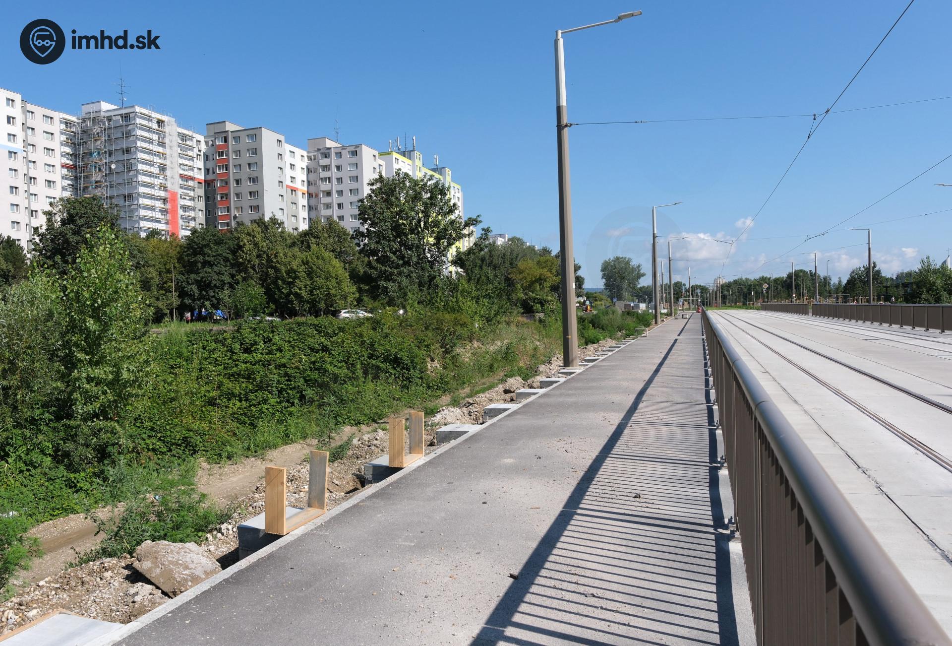 Ešte nedokončené zábradlie na chodníku k zastávke Južné mesto • imhd.sk Bratislava
